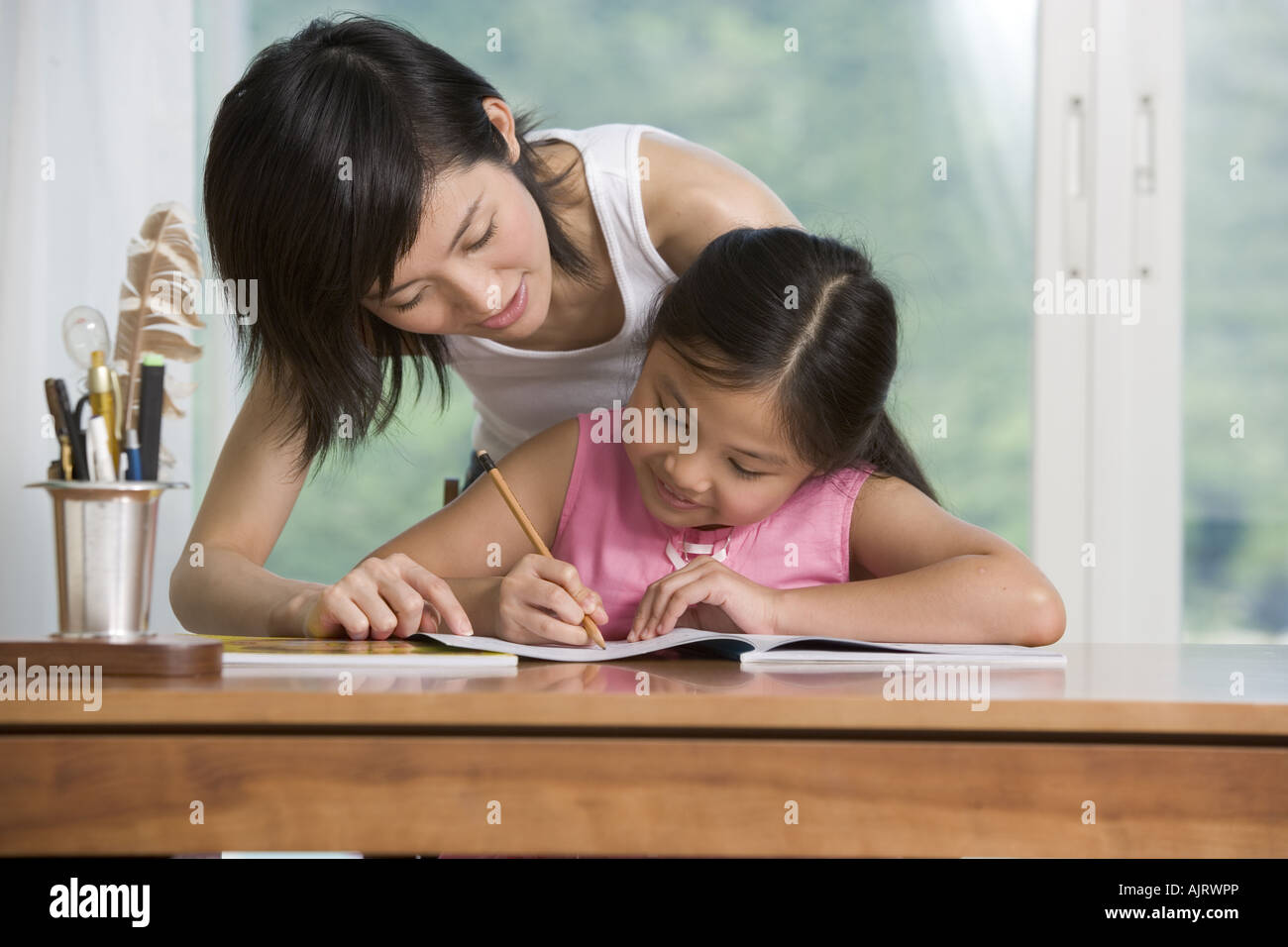Mother helping her daughter with her homework Stock Photo - Alamy