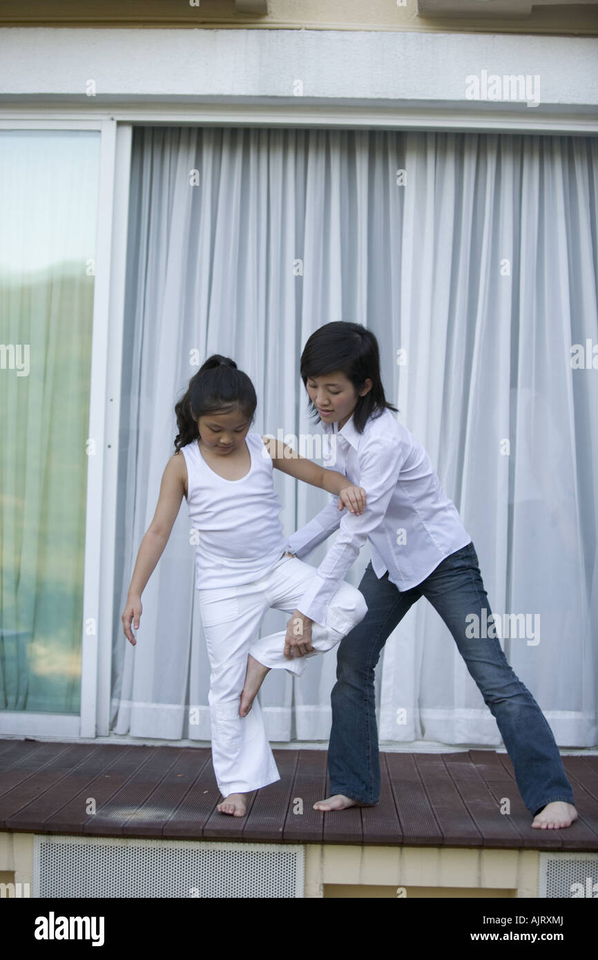 Mother teaching her daughter how to stand on one leg Stock Photo - Alamy