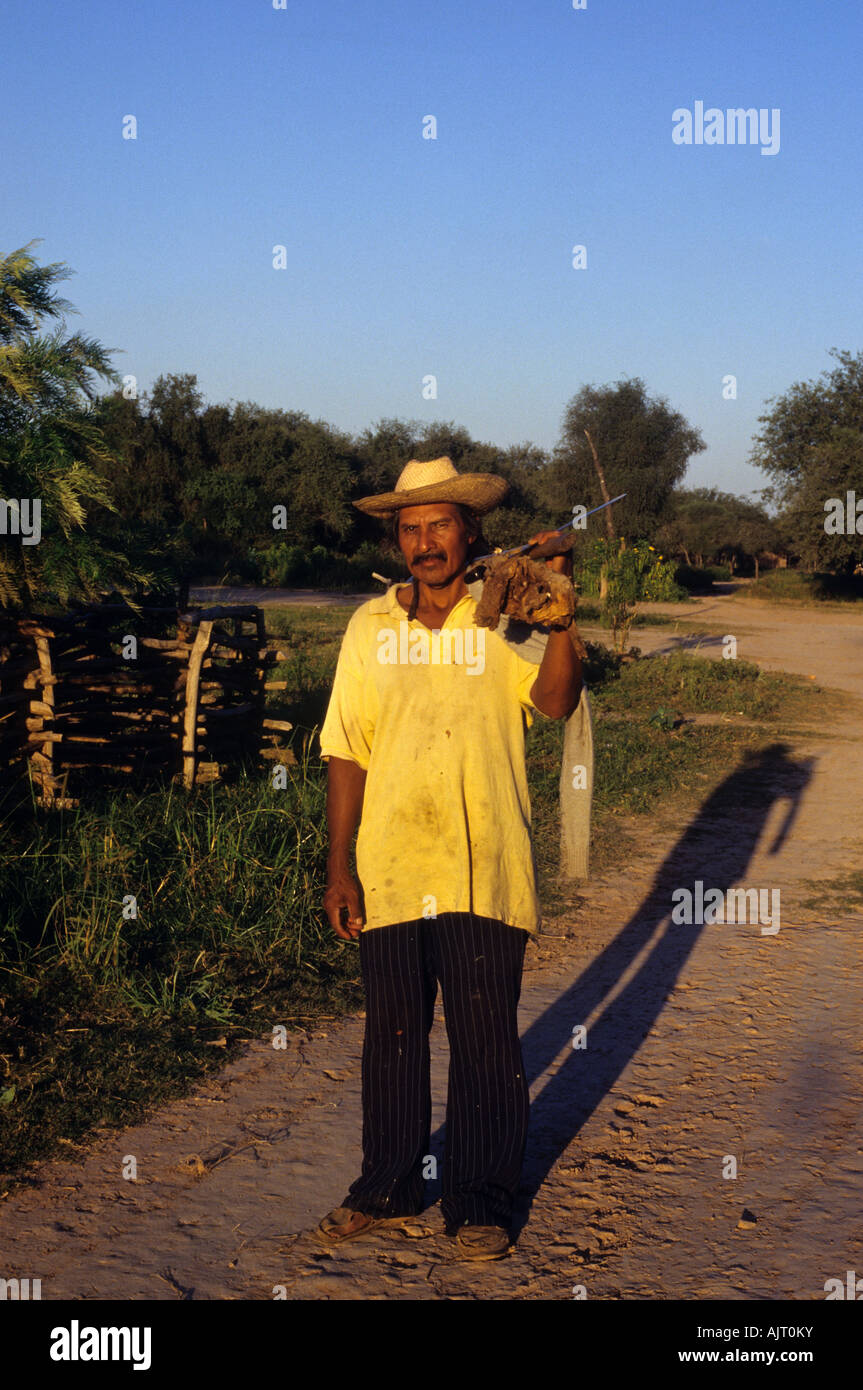 Pilaga man, coming back with a small chunk of wood for the fire in an ...