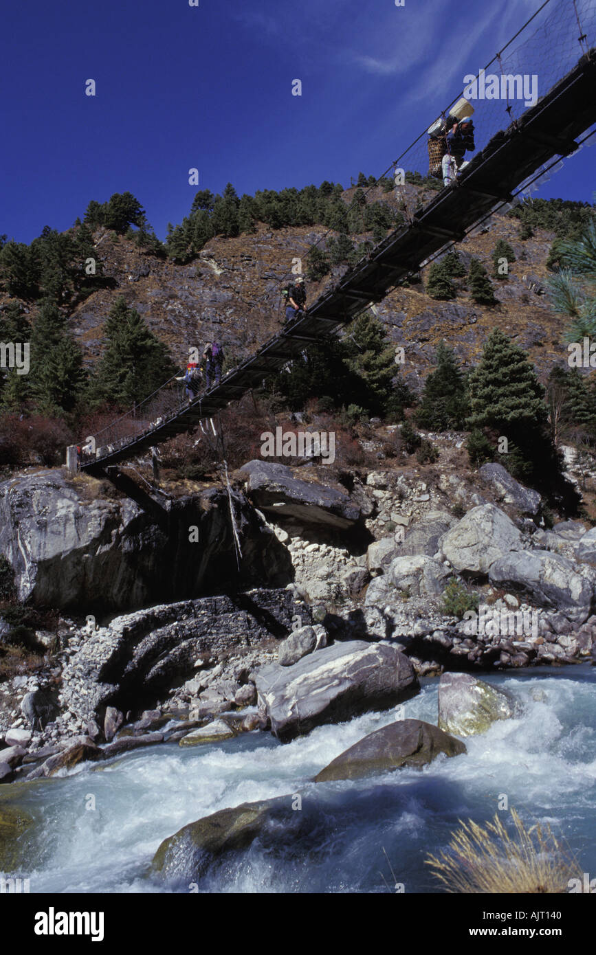 People crossing a rope bridge above a river Stock Photo - Alamy