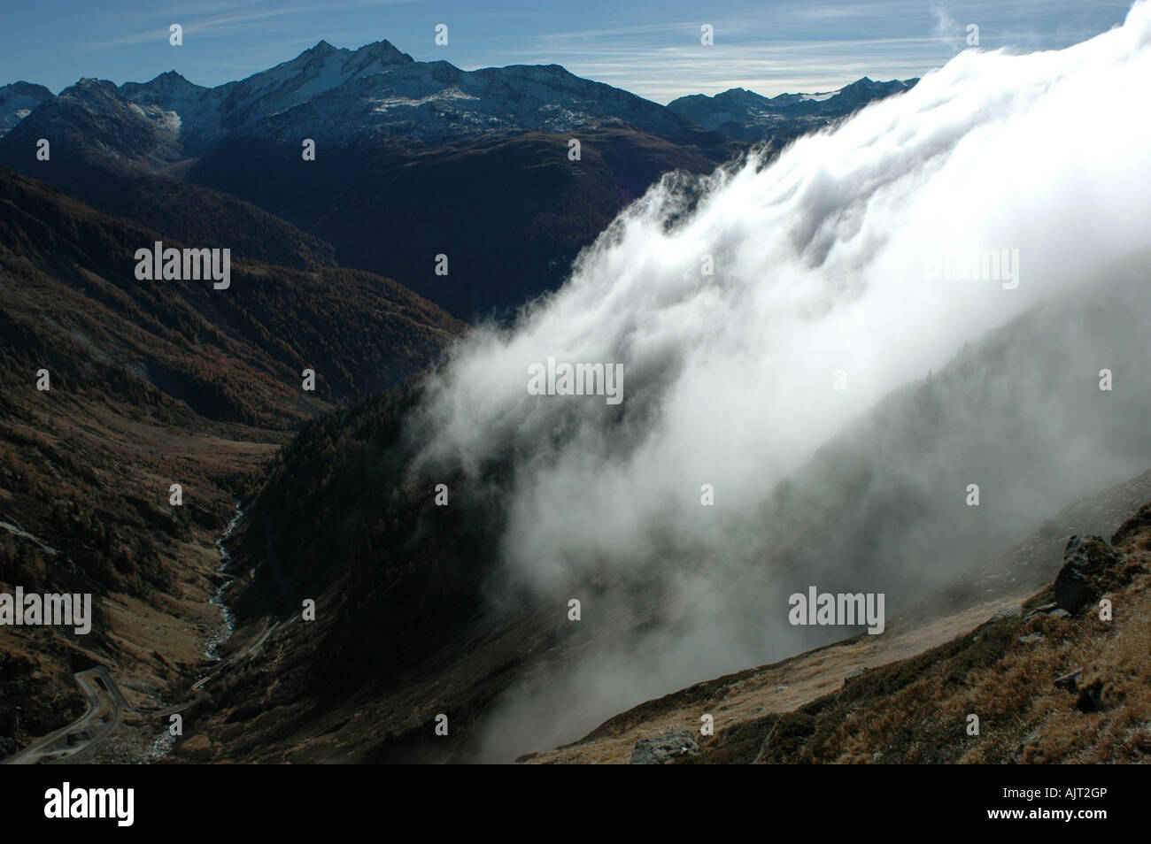 Fog falling from mountain ridge into valley Stock Photo - Alamy