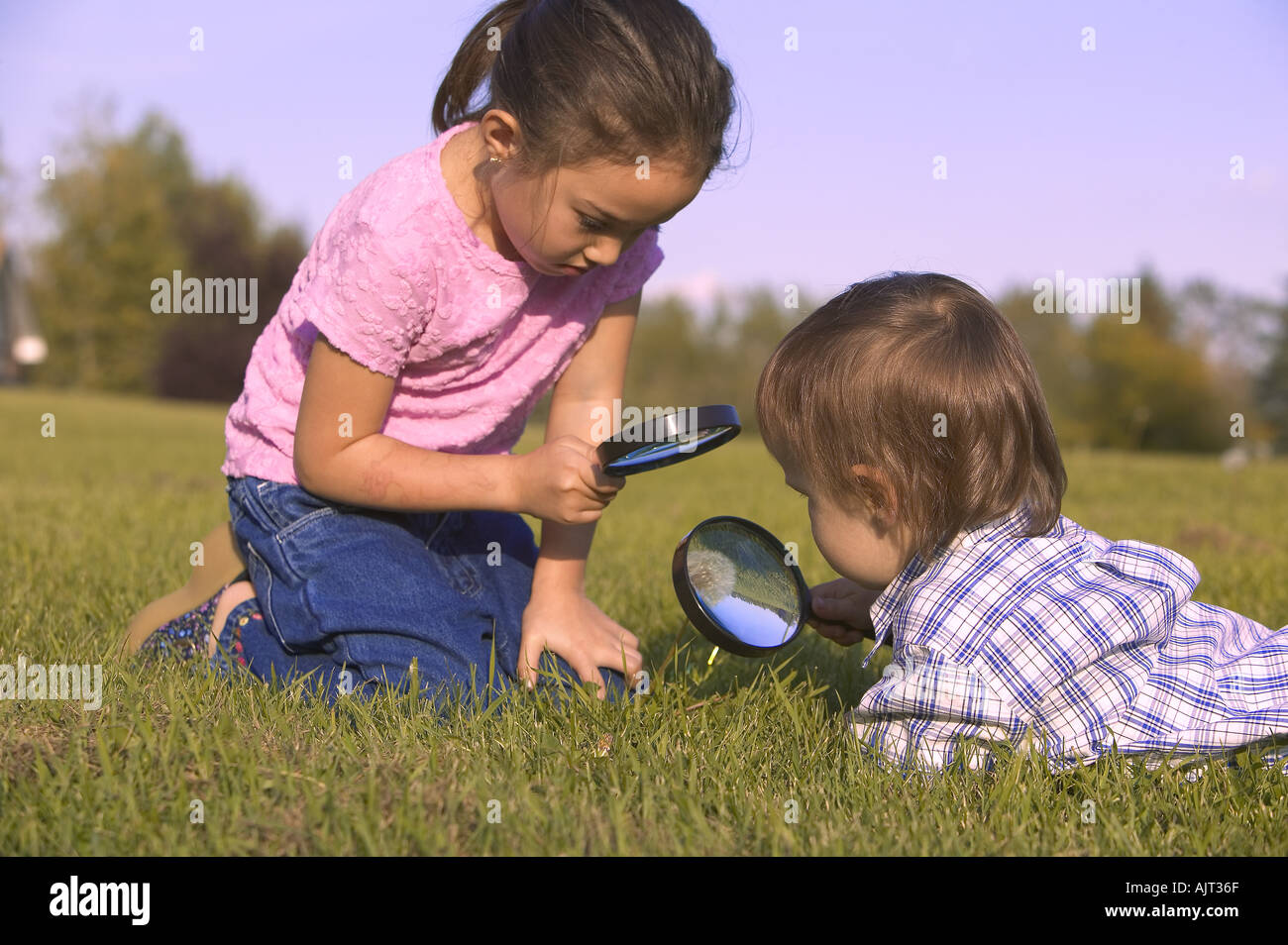 Young children with magnifying glass Stock Photo - Alamy
