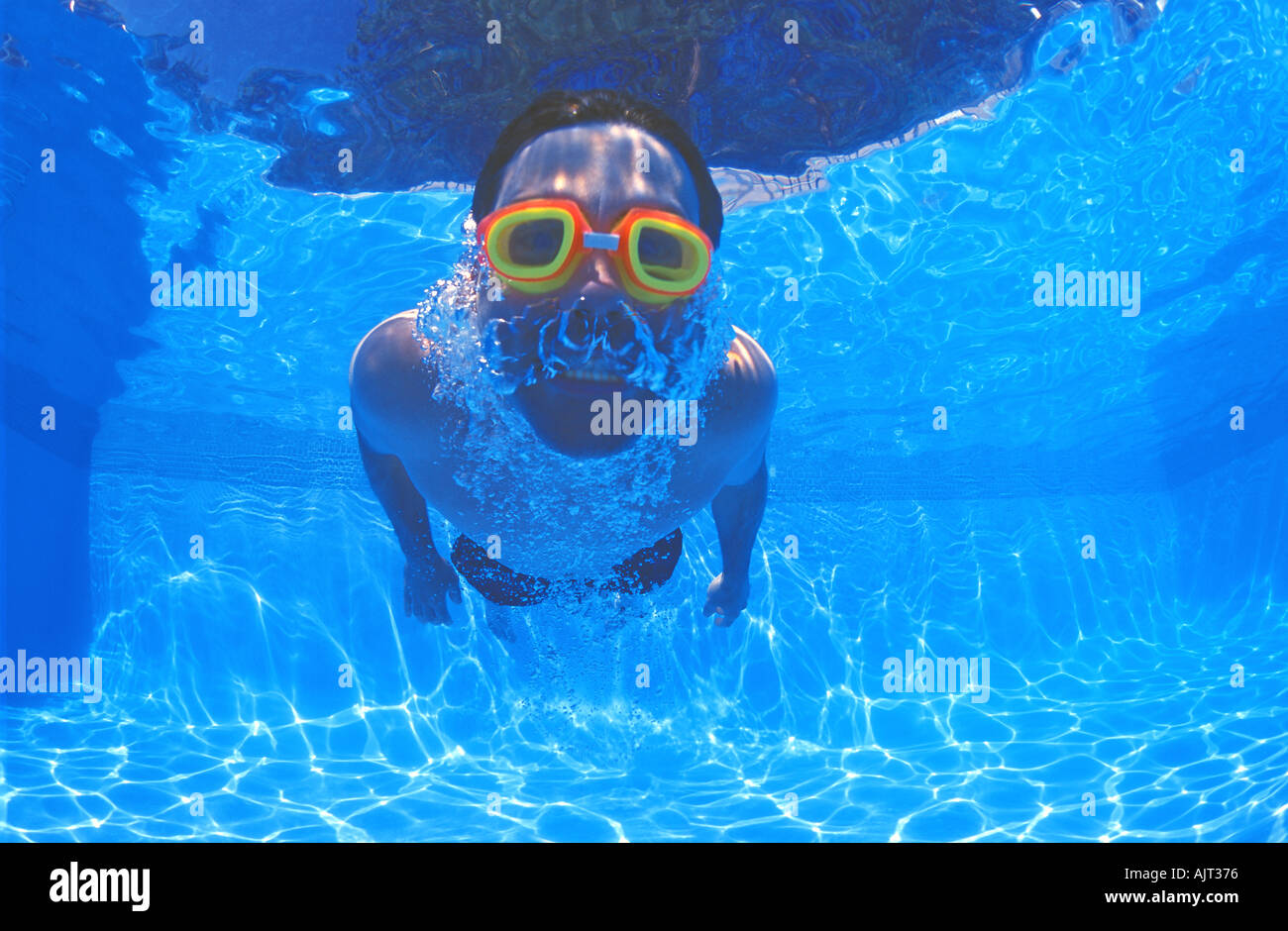 Boy with goggles in swimming pool Stock Photo - Alamy