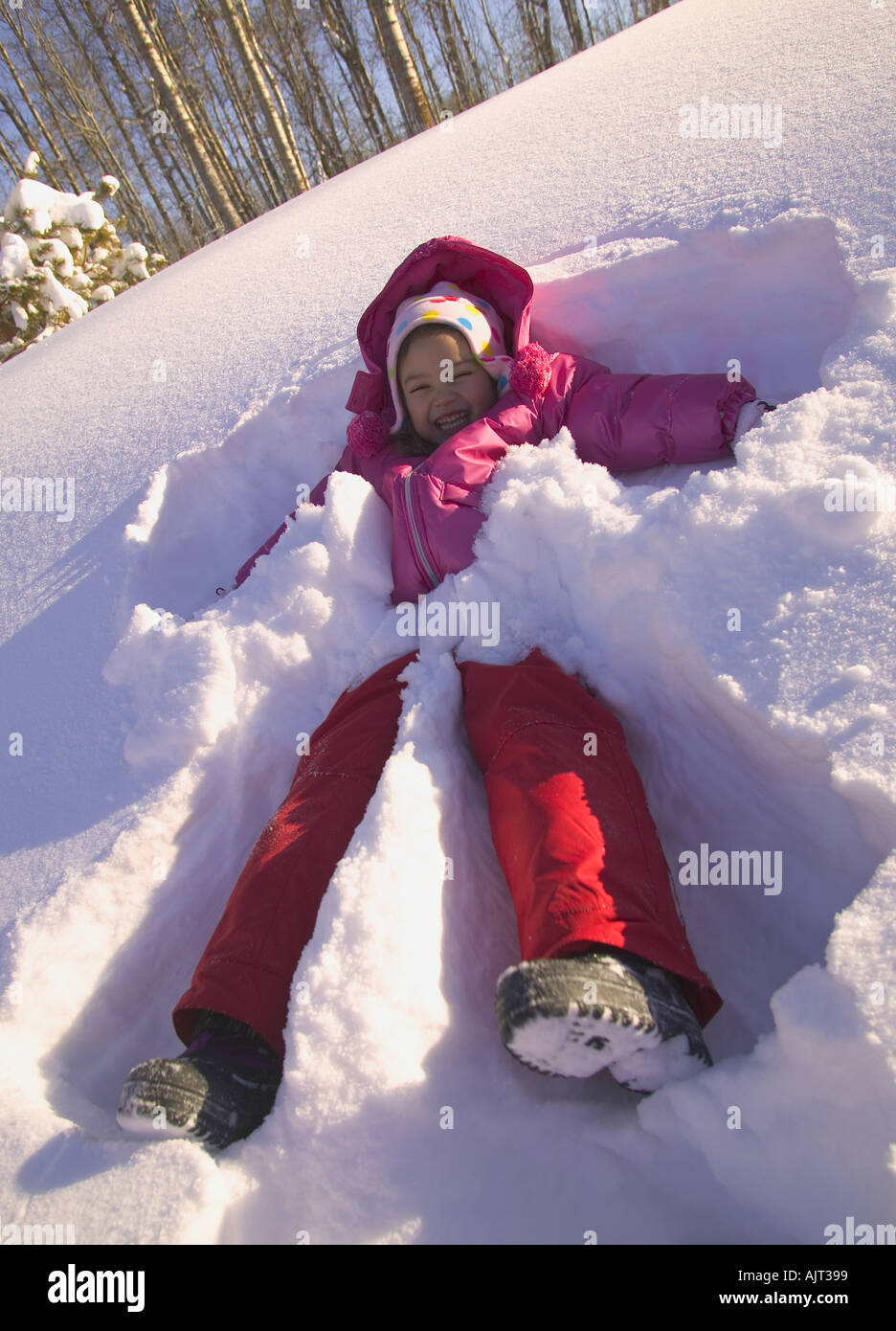 Girl making a snow angel Stock Photo - Alamy