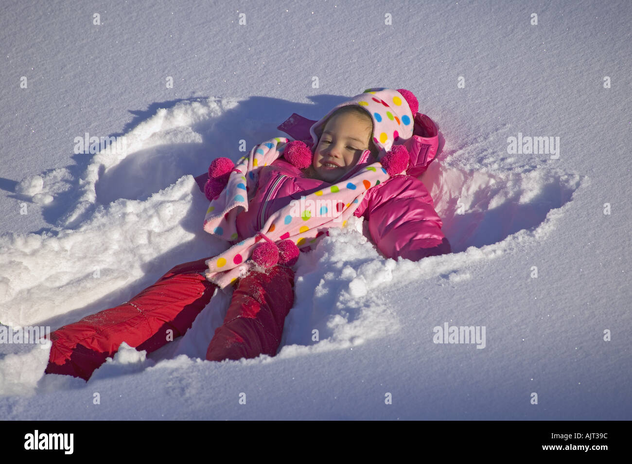 Girl making snow angel Stock Photo - Alamy