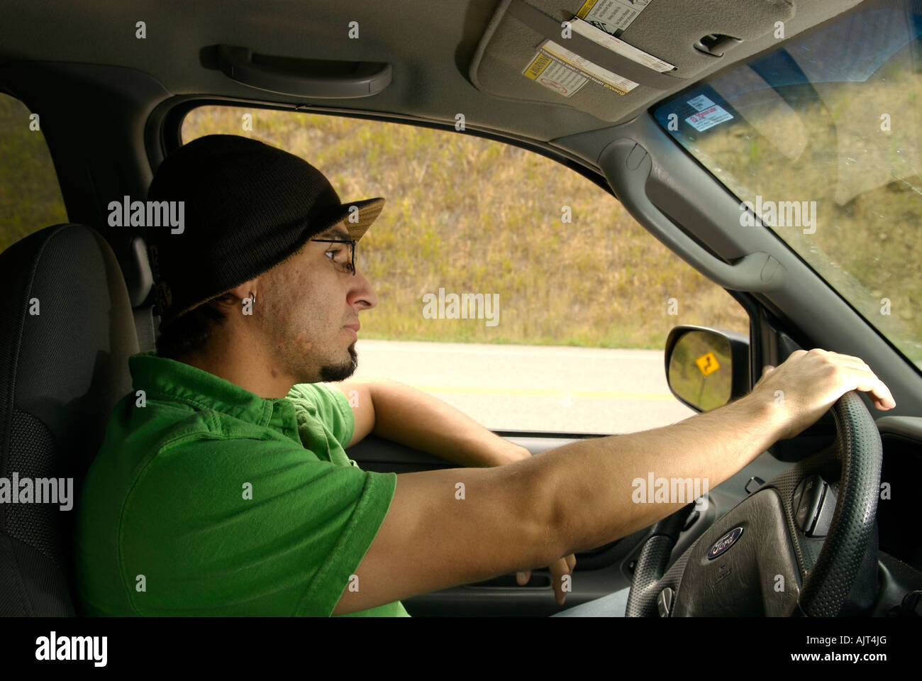 Side view of a Hispanic man sitting behind the steering wheel of a SUV ...