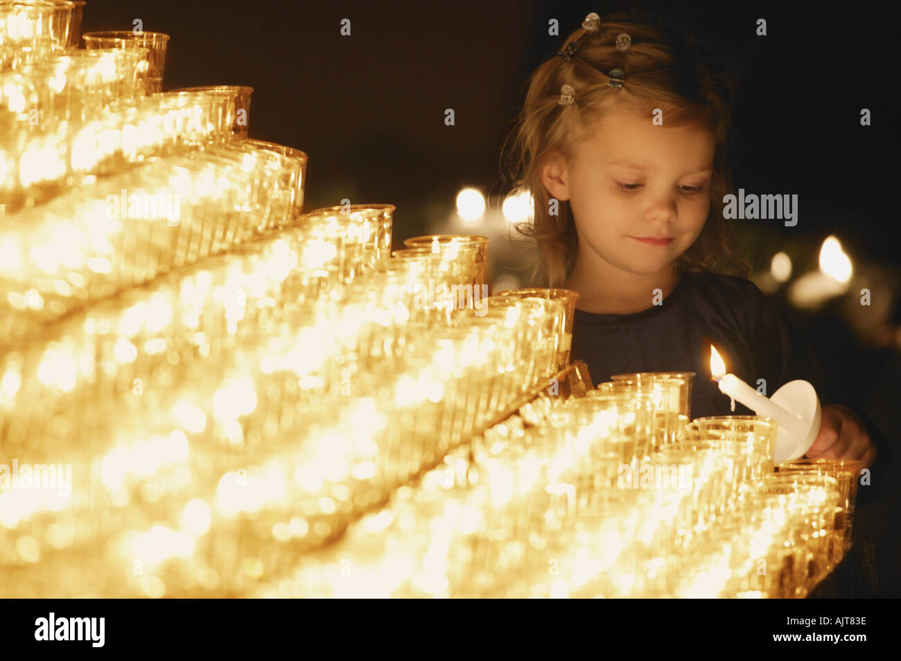 Young girl lighting a candle Stock Photo - Alamy