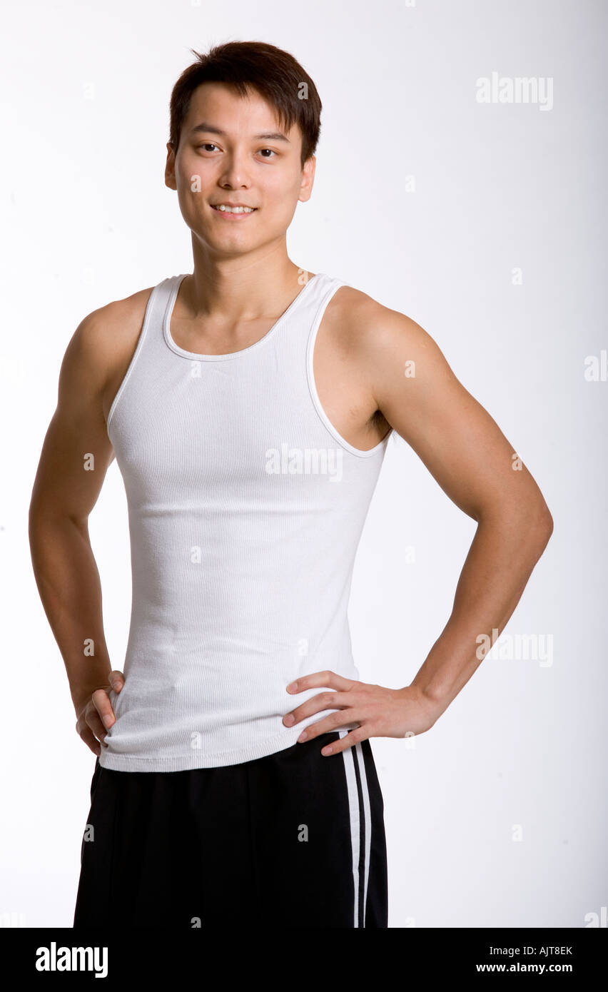 Portrait of a young man standing with arms akimbo Stock Photo - Alamy