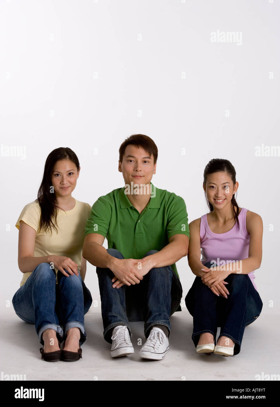 Portrait of a young man sitting between two young women Stock Photo - Alamy