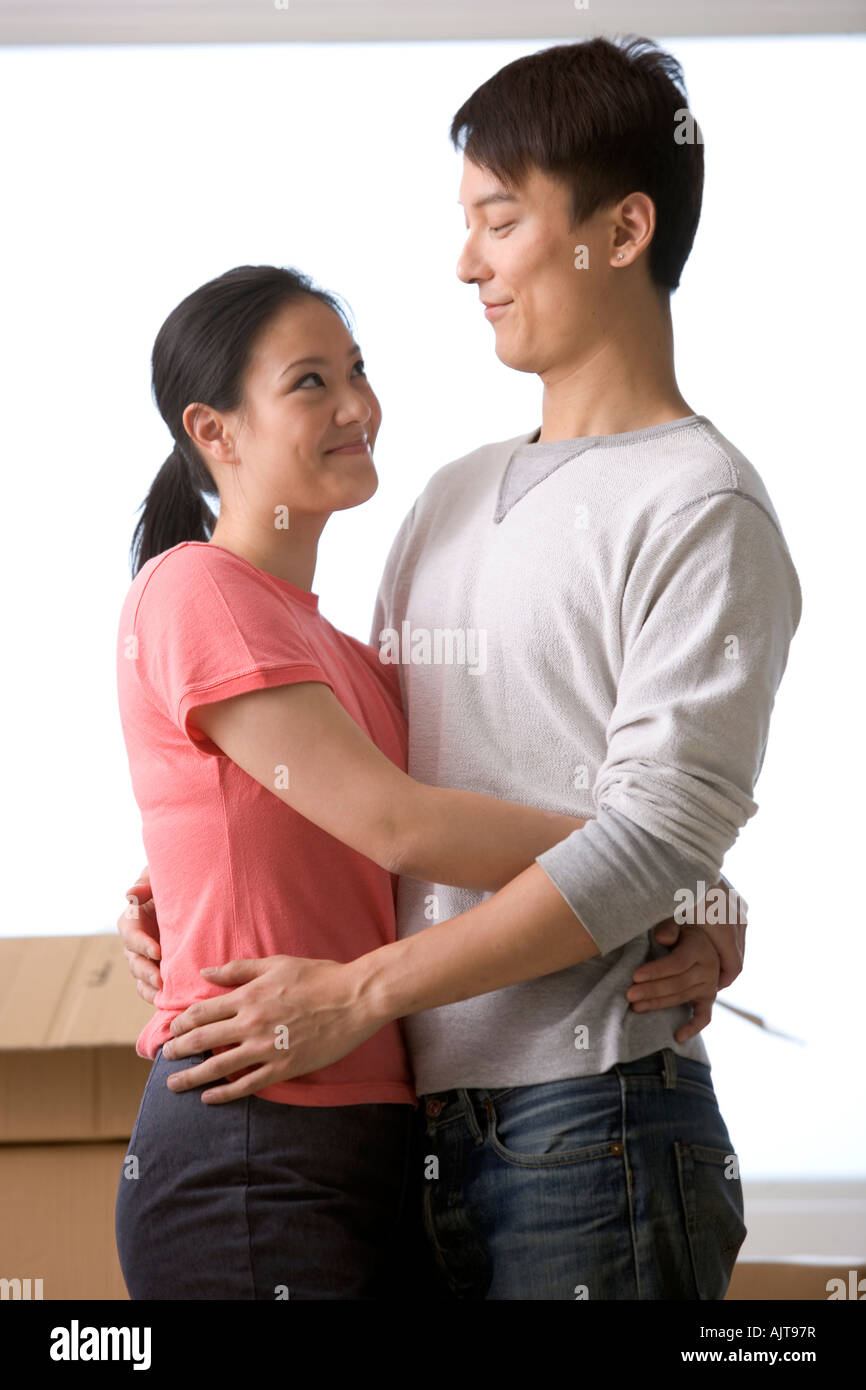 Young couple embracing each other and smiling Stock Photo - Alamy