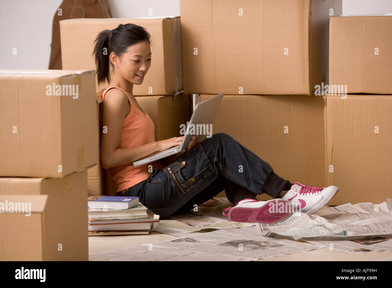 Side profile of a young woman sitting and using a laptop Stock Photo ...