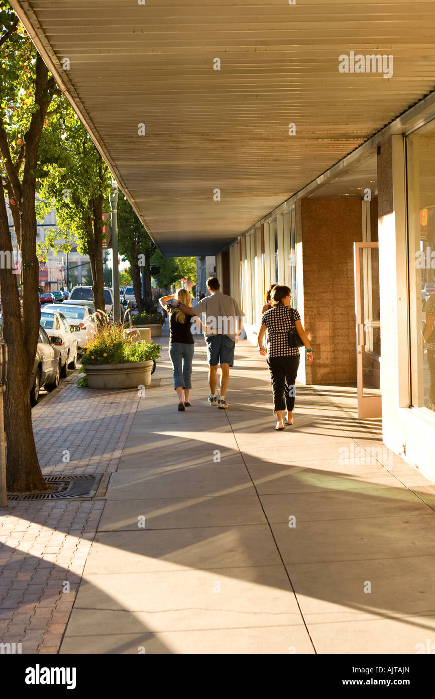Couple walking down city street Stock Photo - Alamy