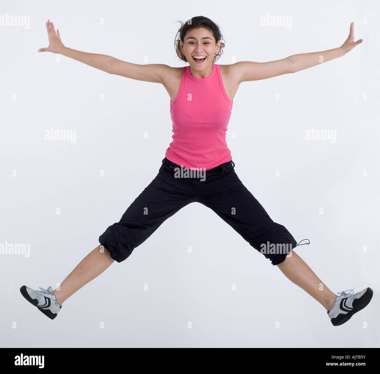 Portrait of a young woman jumping with her arm outstretched Stock Photo ...