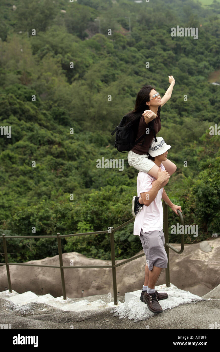 Side profile of a young man carrying a young woman on his shoulders ...