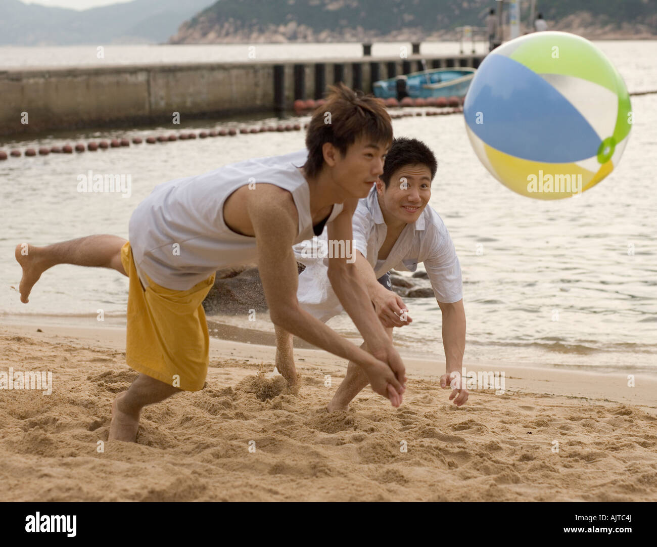 Two young men playing with a beach ball on the beach Stock Photo - Alamy