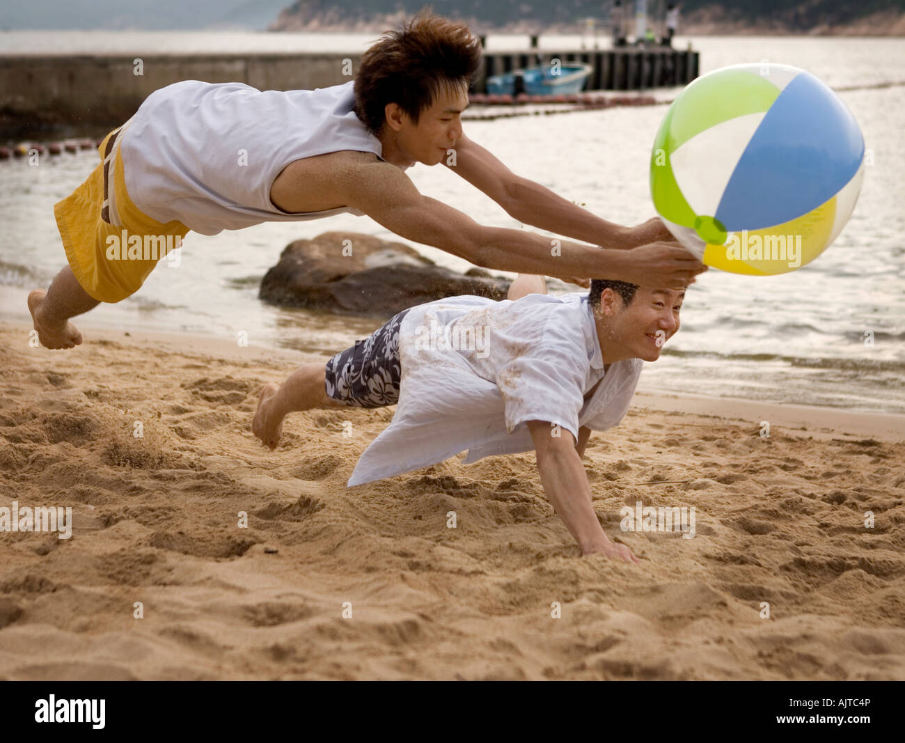 Two young men playing with a beach ball on the beach Stock Photo - Alamy