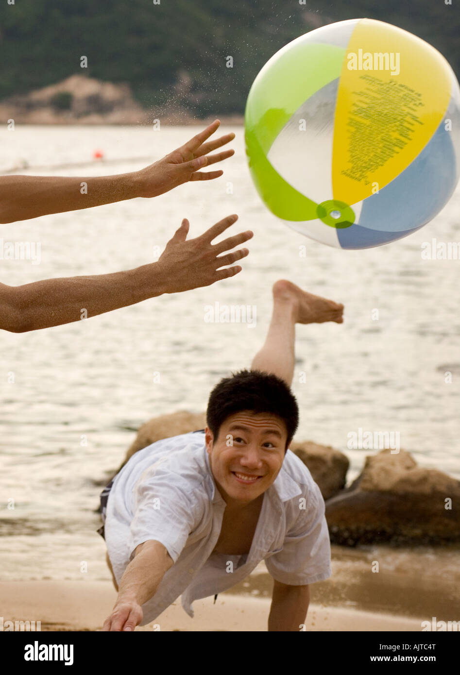 Two young men playing with a beach ball on the beach Stock Photo - Alamy