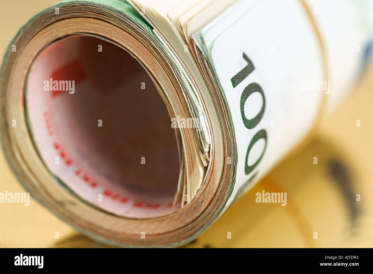 Roll of Euro banknotes on golden background Stock Photo - Alamy