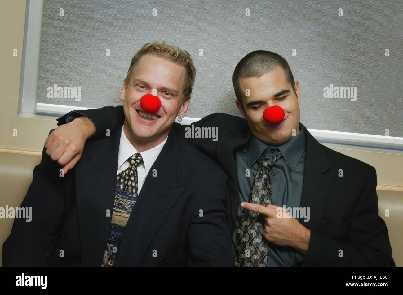 Two Businessmen being silly wearing red noses Stock Photo - Alamy
