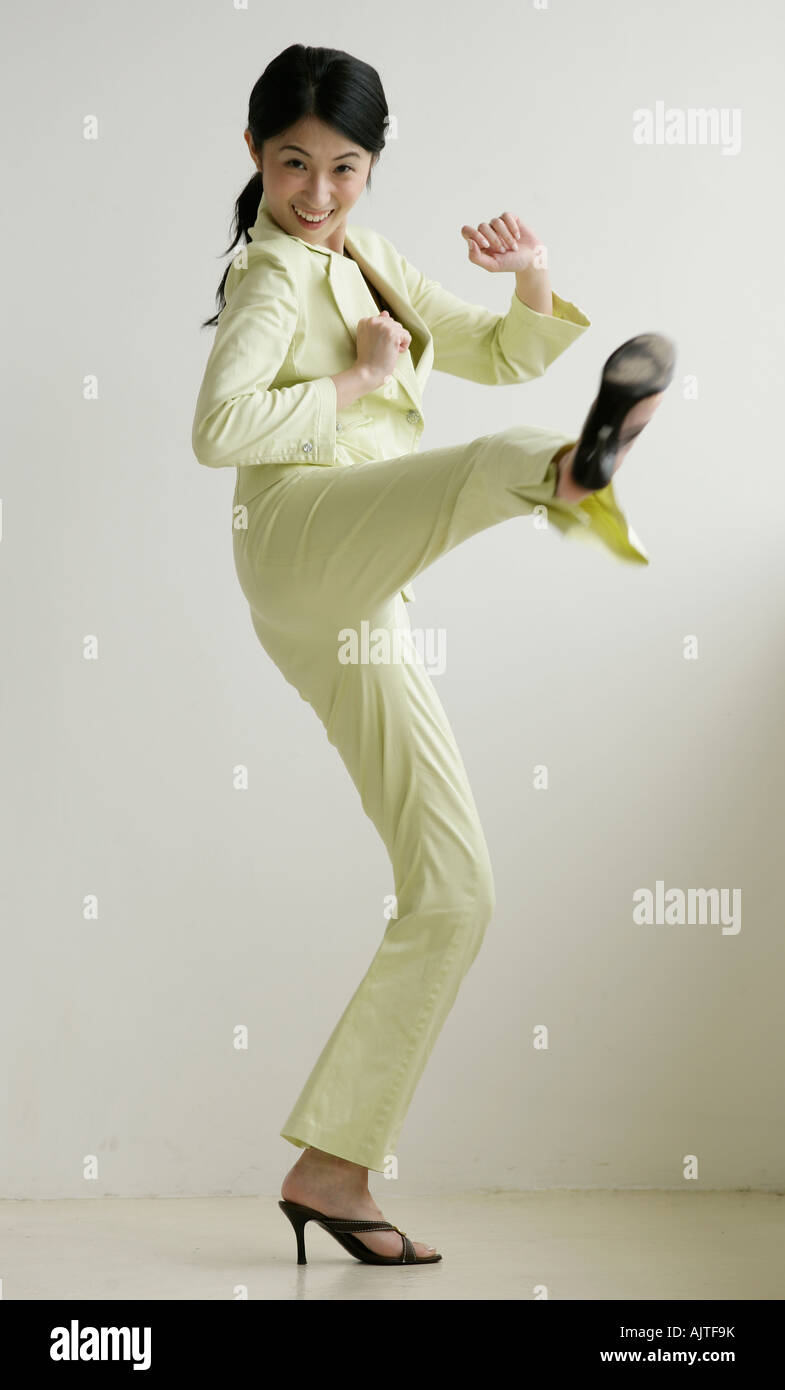 Portrait of a young woman kicking Stock Photo - Alamy