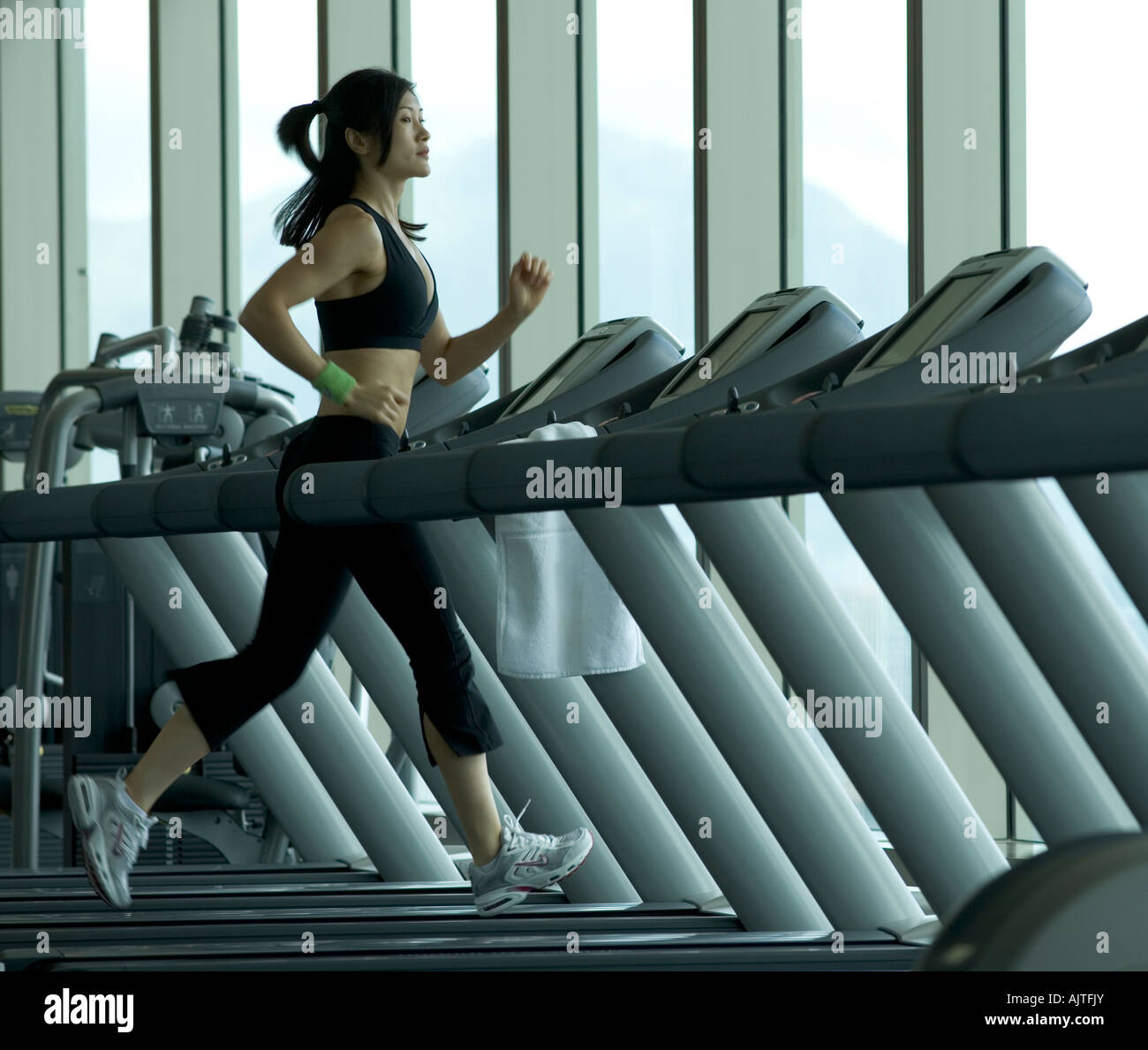 Side profile of a mid adult woman running on a treadmill Stock Photo ...