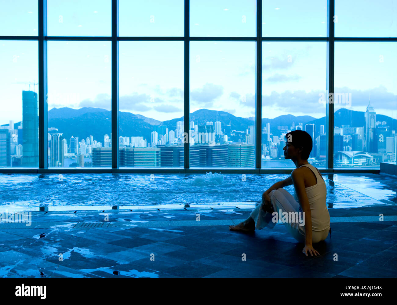 Side profile of a young woman sitting near a hot tub Stock Photo - Alamy