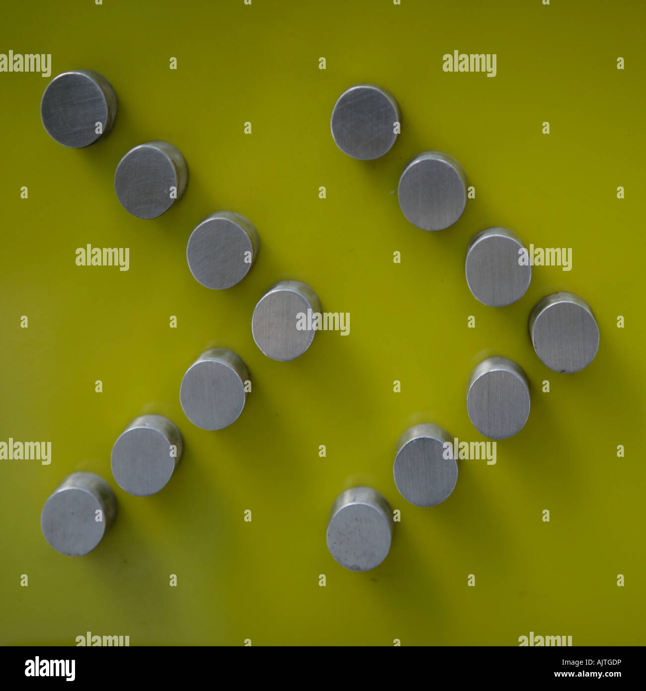 Close-up of metal buttons in the shape of an arrow Stock Photo - Alamy