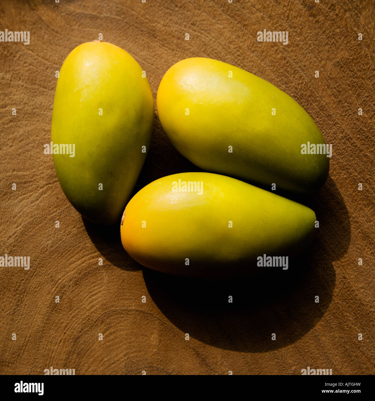 Still life of three wooden mangoes on plate Stock Photo - Alamy