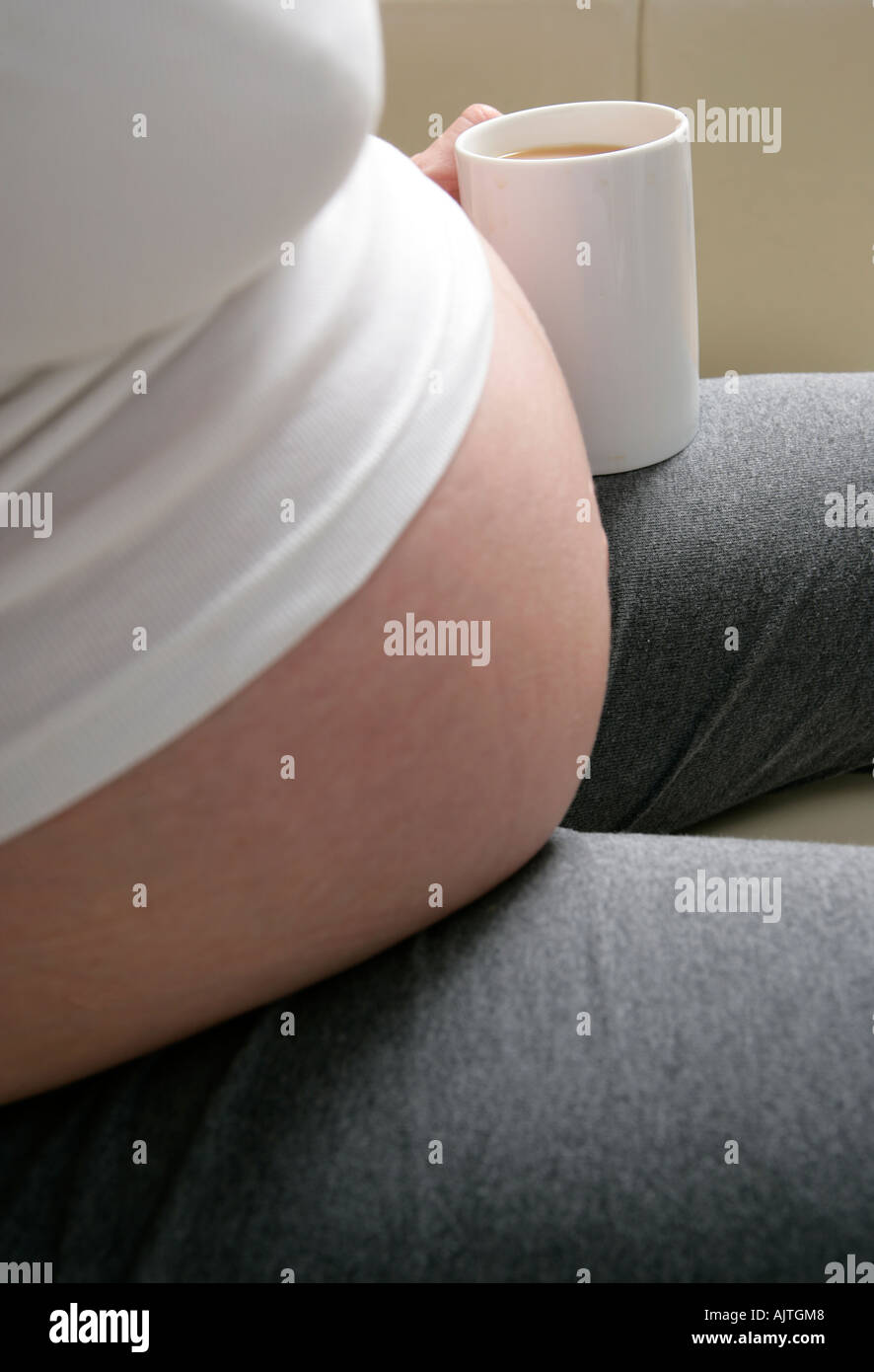 Pregnant woman with a mug Stock Photo - Alamy