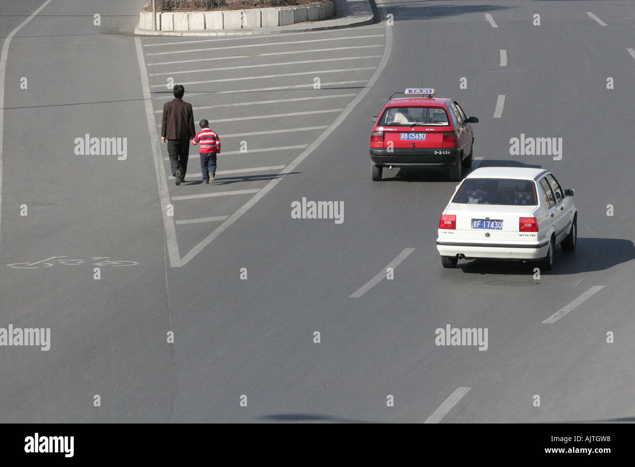 adult and child walk down the 2nd ring road at Chaoyangmen central ...