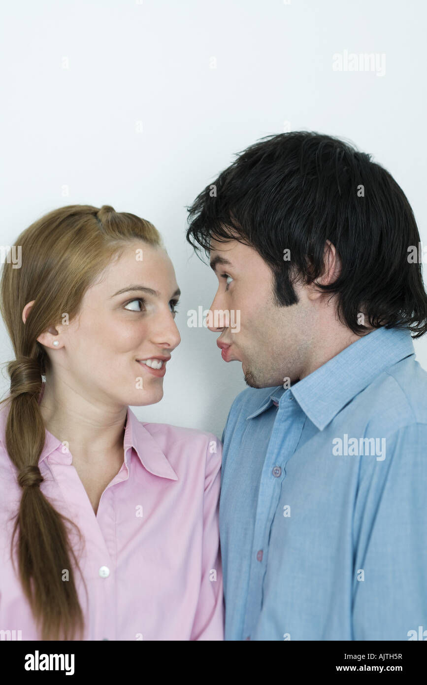 Young couple making goofy faces at each other, head and shoulders ...