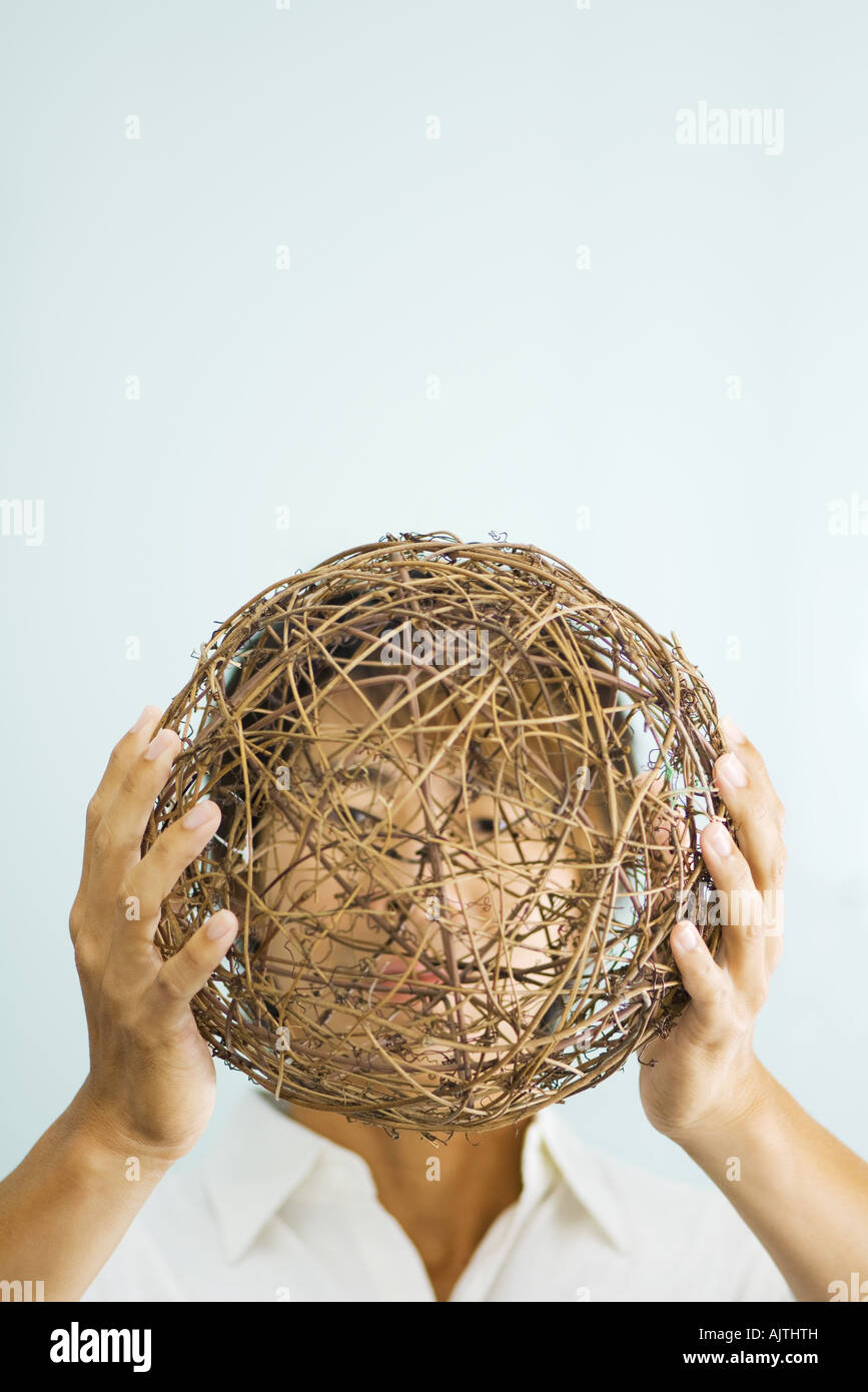 Man holding up wicker sphere in front of face Stock Photo - Alamy