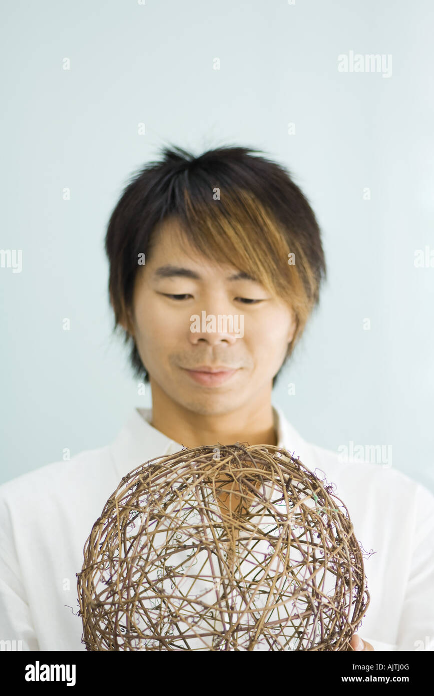 Man holding wicker sphere, smiling, head and shoulders Stock Photo - Alamy