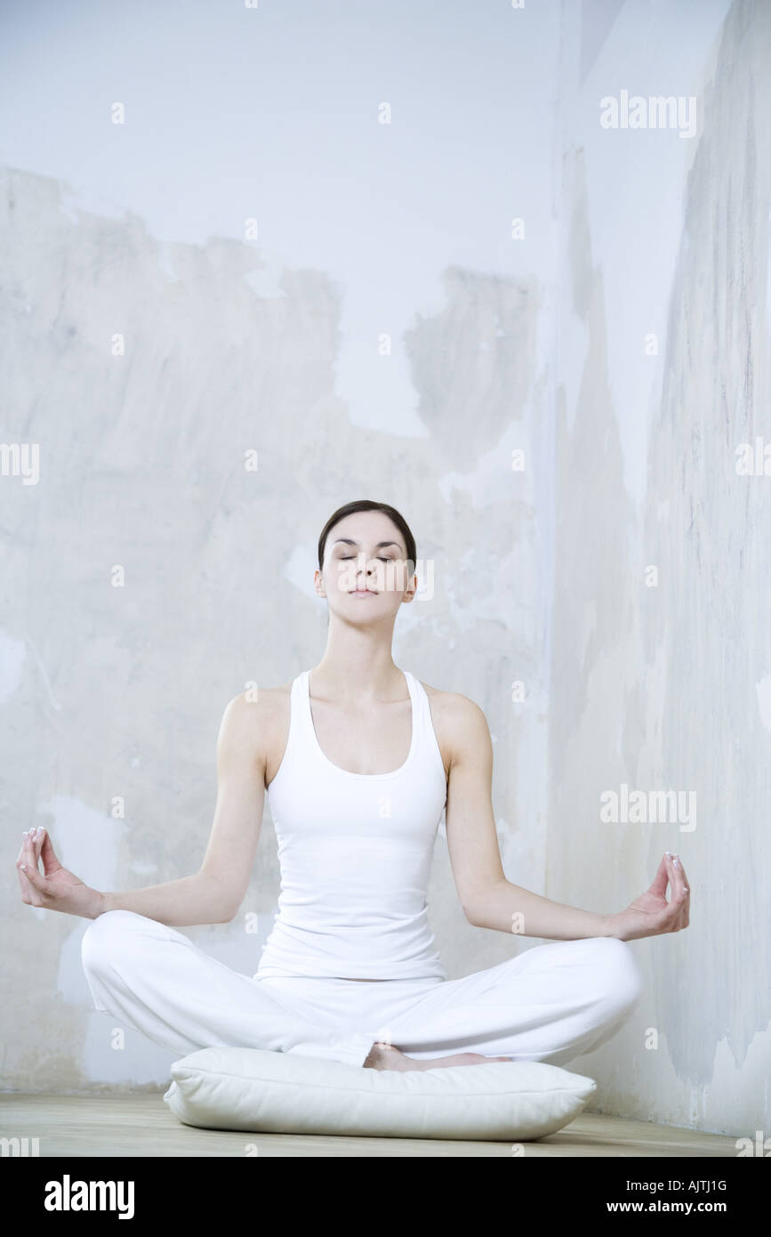 Young woman sitting in lotus position, eyes closed, full length Stock ...
