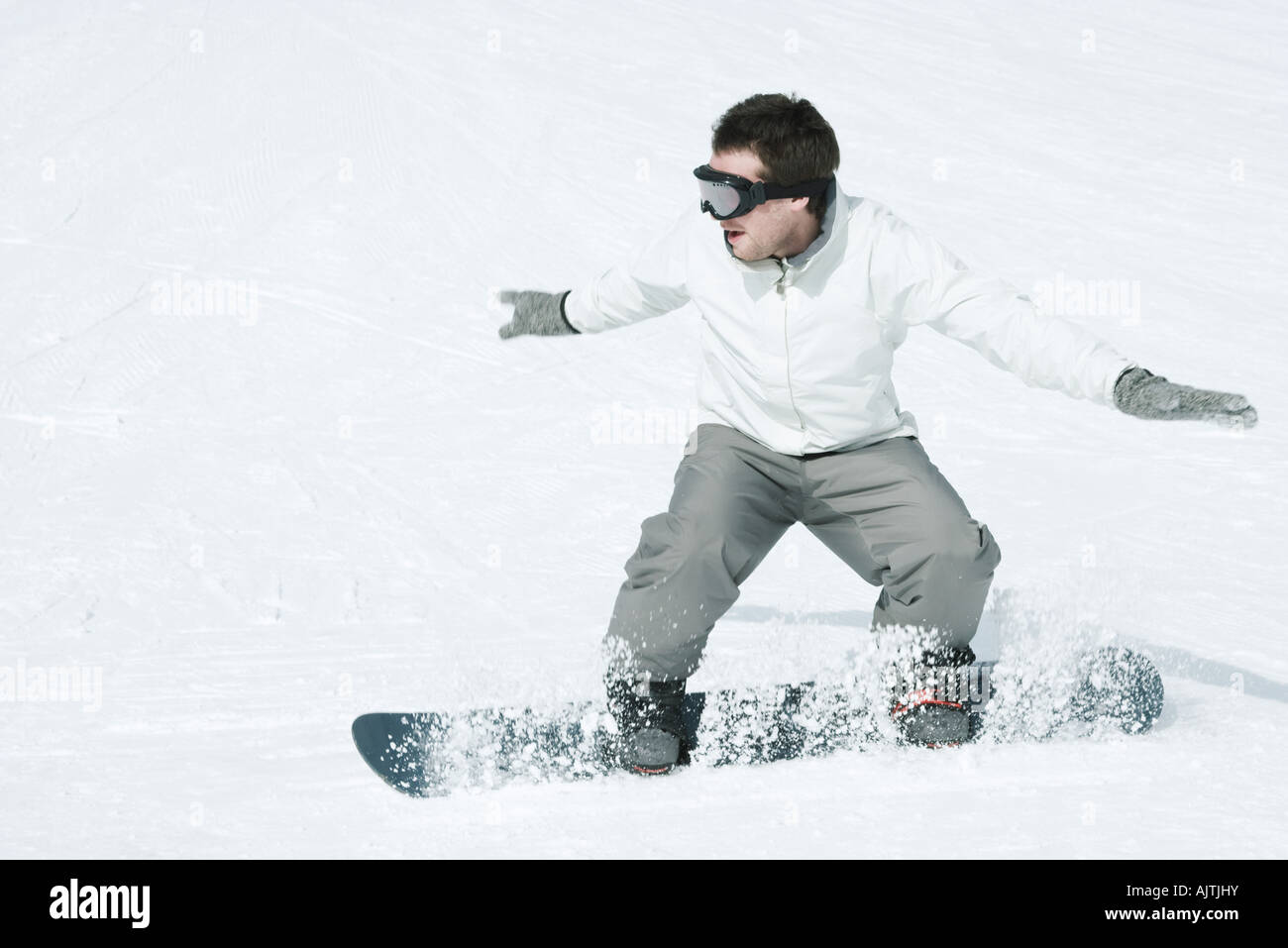 Young man snowboarding, action shot, full length Stock Photo - Alamy