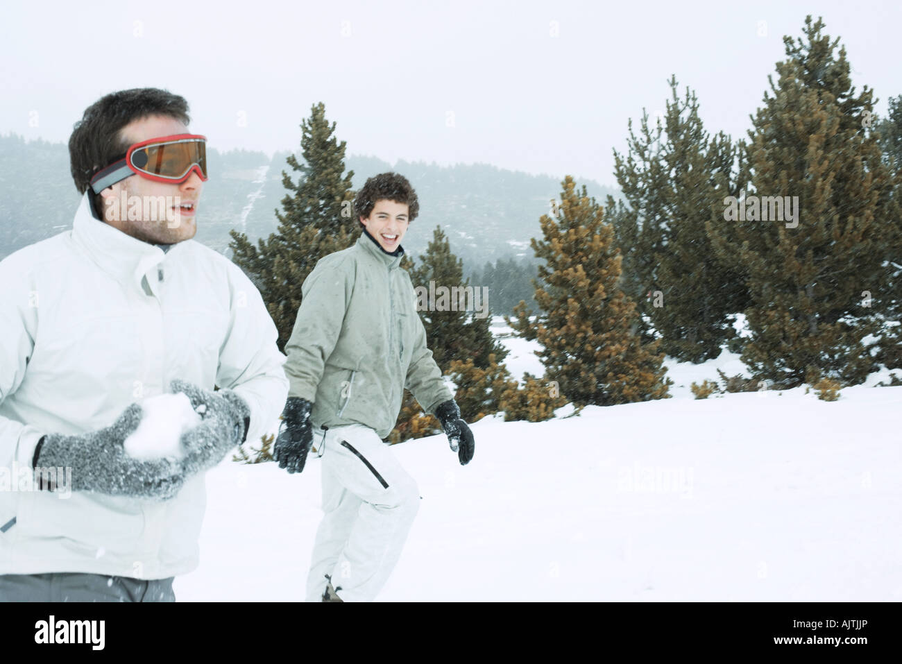 Young male friends in the snow, one holding a snowball Stock Photo - Alamy
