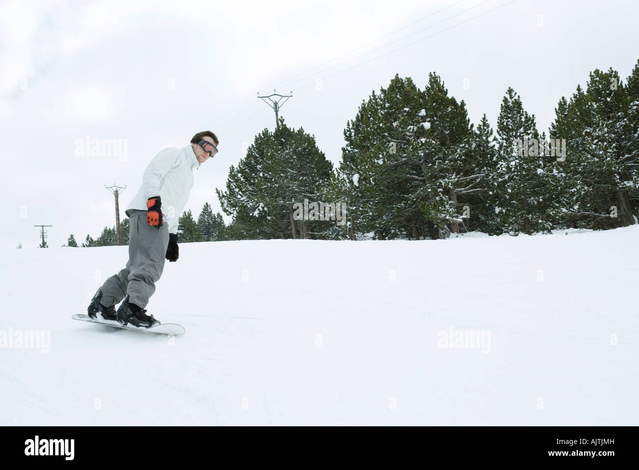 Young man snowboarding, full length Stock Photo - Alamy