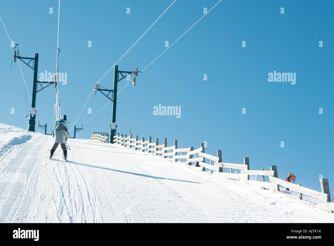 Young skier going up hill on ski lift, rear view Stock Photo - Alamy