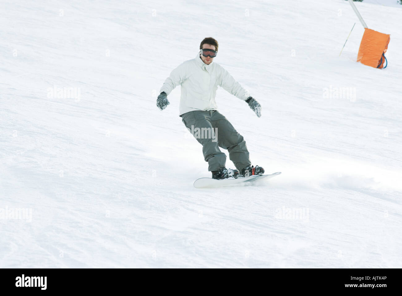 Young man snowboarding on ski slope, full length Stock Photo - Alamy