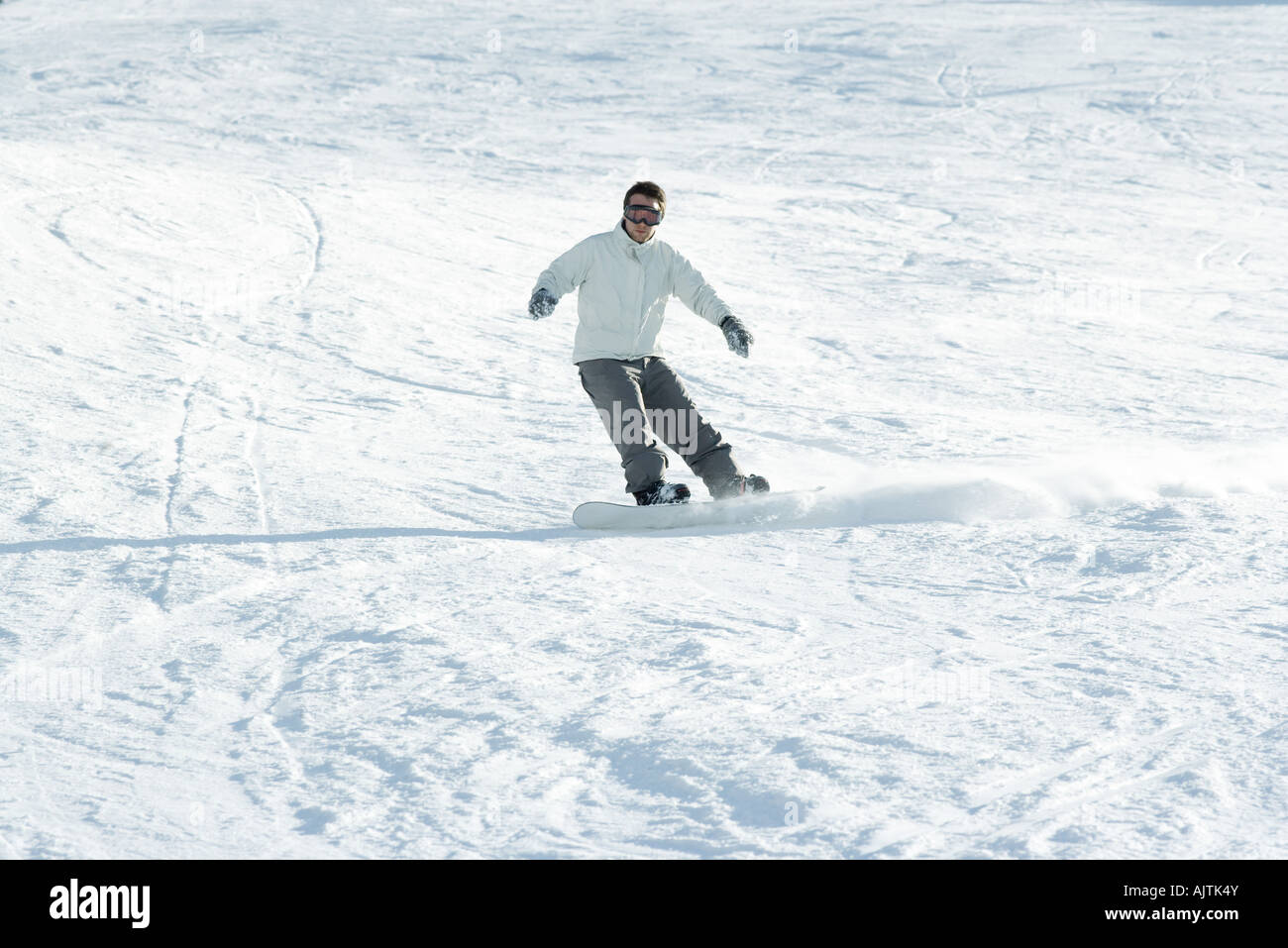 Young man snowboarding down ski slope, full length Stock Photo - Alamy