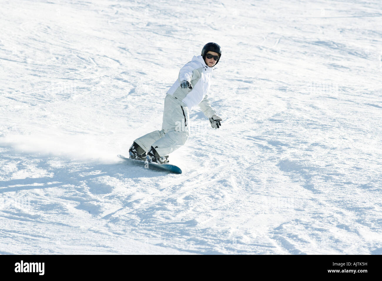 Teenage girl snowboarding down ski slope, full length Stock Photo - Alamy