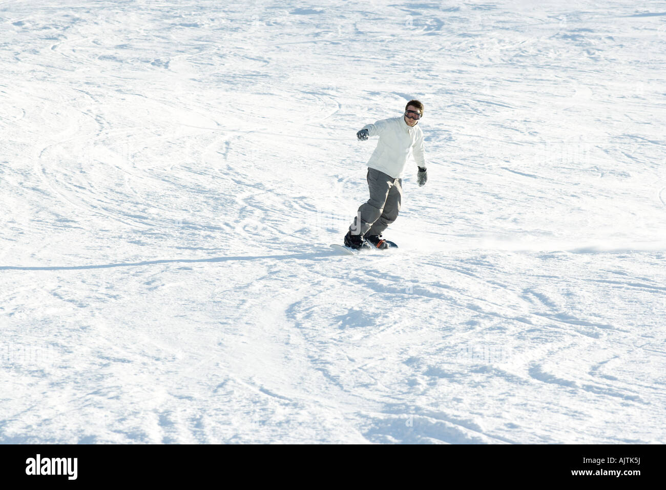 Young man snowboarding down ski slope, full length Stock Photo - Alamy