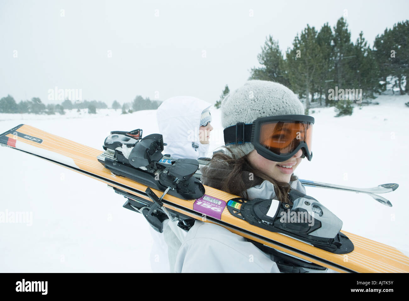 Two young skiers walking together, carrying skis on shoulders Stock ...