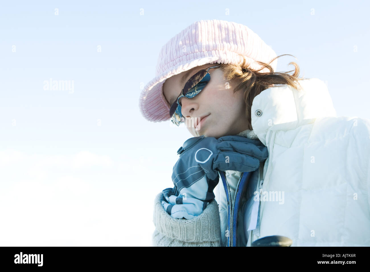 Young skier leaning on skis, hand under chin, looking down Stock Photo ...