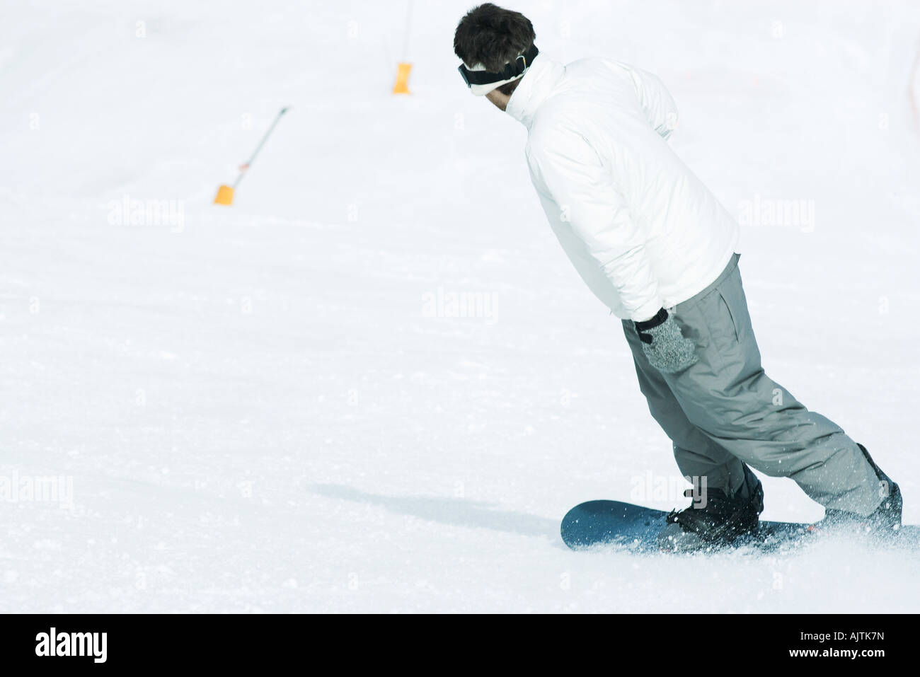 Young man snowboarding down ski slope, rear view Stock Photo - Alamy