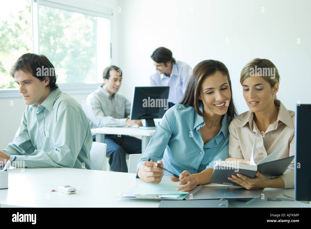 Colleagues working together in office Stock Photo - Alamy