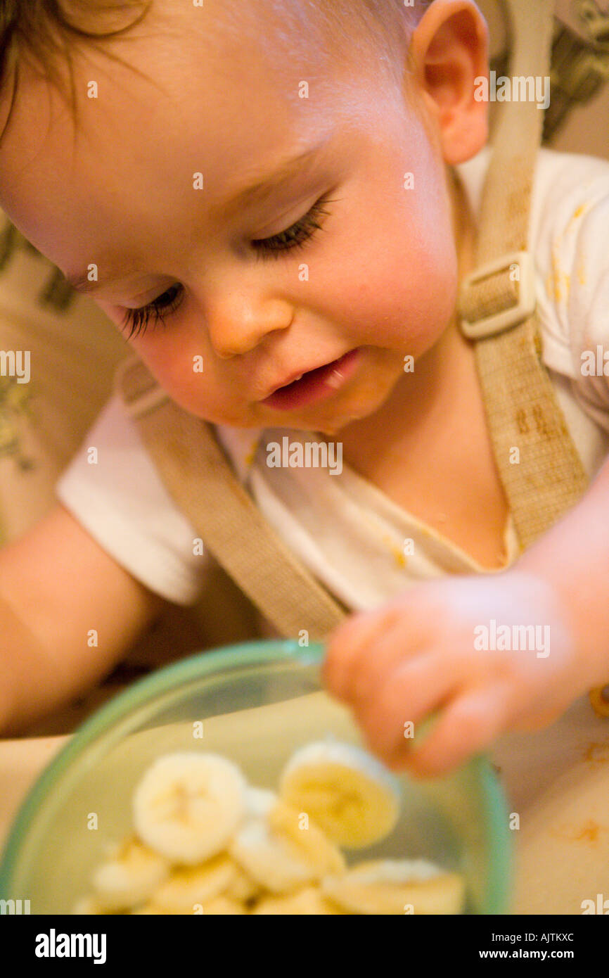shot of a baby 1 year old at meal time eating bannanas Stock Photo - Alamy