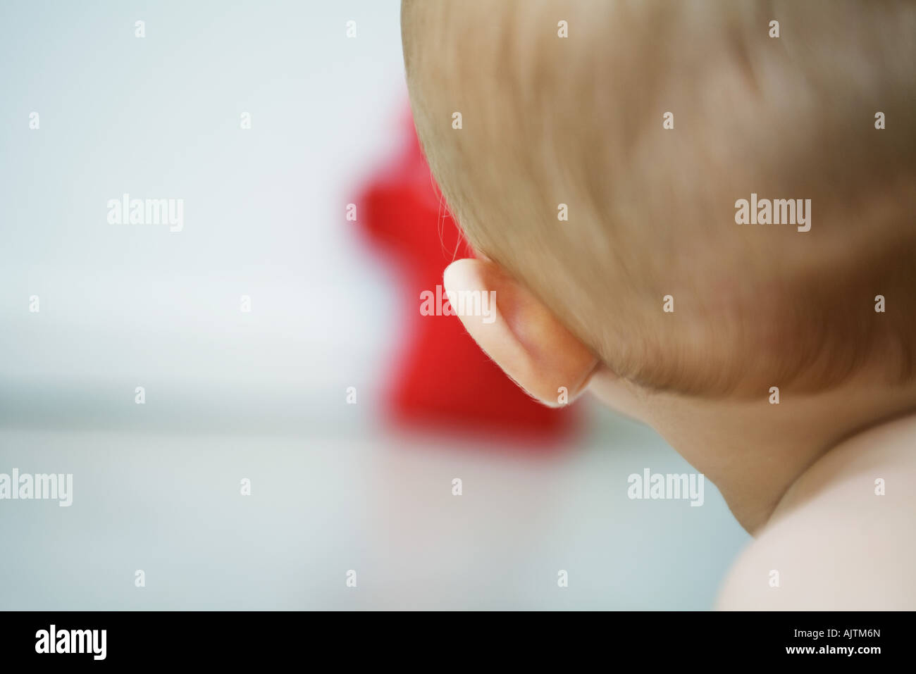 Baby with head turned toward toy, rear cropped view, close-up Stock ...