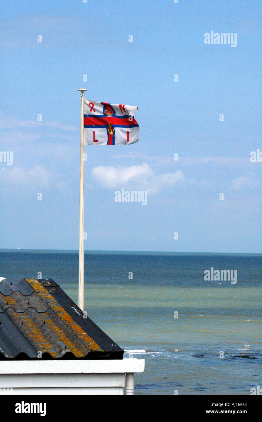 RNLI flag flying on rooftop of RNLI building with the sea in the ...
