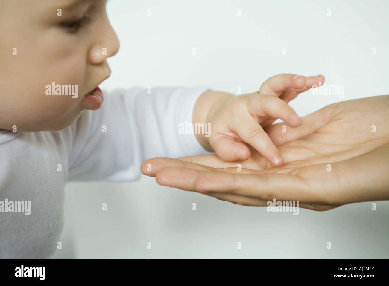 Baby inspecting mother's palm, close-up, cropped view Stock Photo - Alamy
